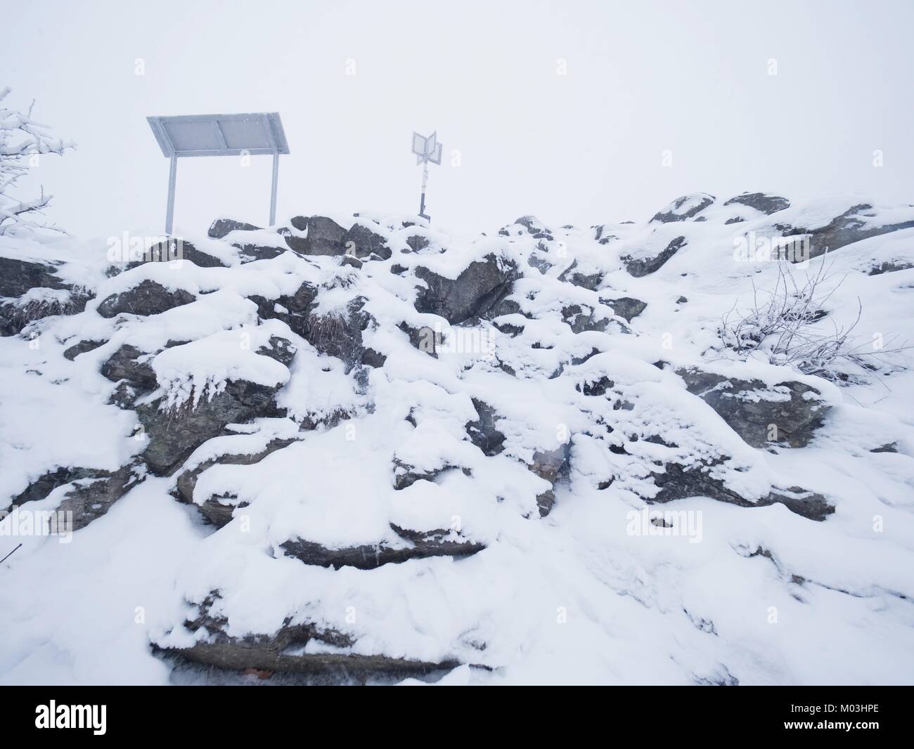Close up to rocky terrain with fresh powder snow, landscape hidden in ...
