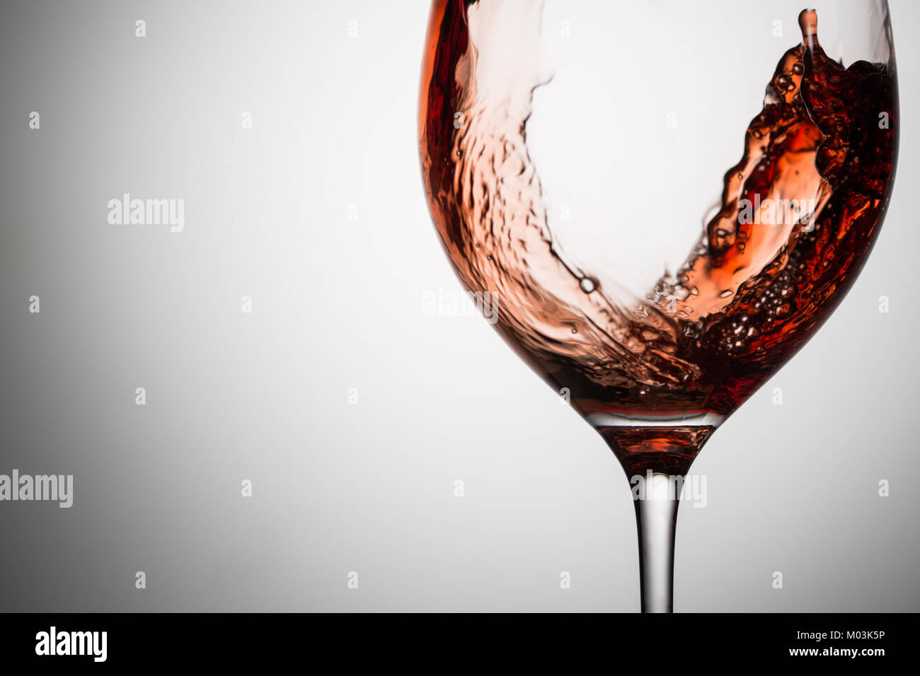 Moving red wine in transparent wineglass Stock Photo - Alamy