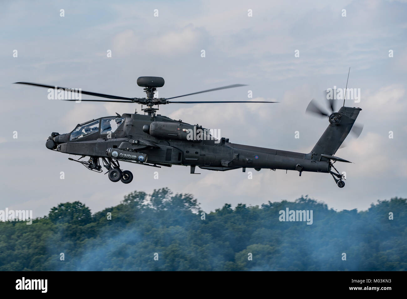 British Army Apache AH1 helicopter about to land through clearing smoke ...