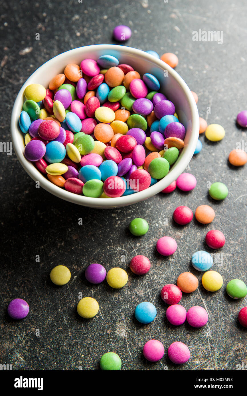 Colorful chocolate candies in bowl on old kitchen table Stock Photo - Alamy