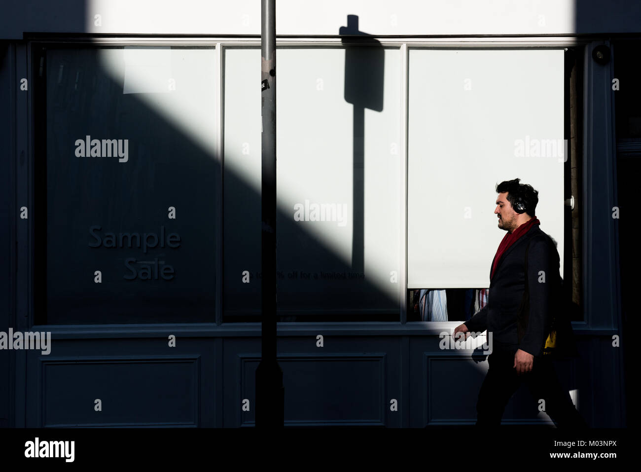 Low summer sun cast dark shadows and bright light. In this image a male ...