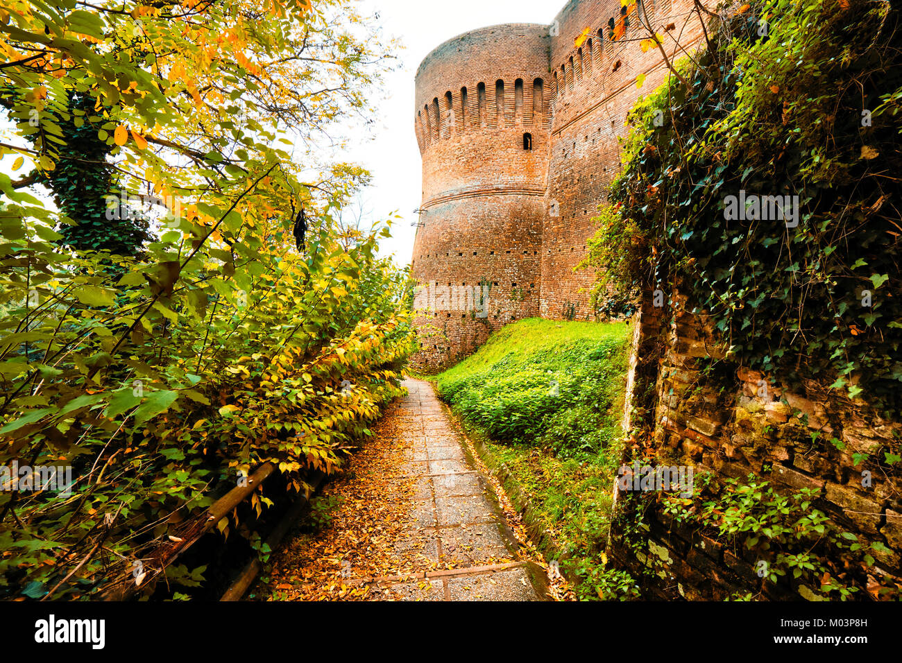 paved path near ancient walls of medieval castle in a green forest ...