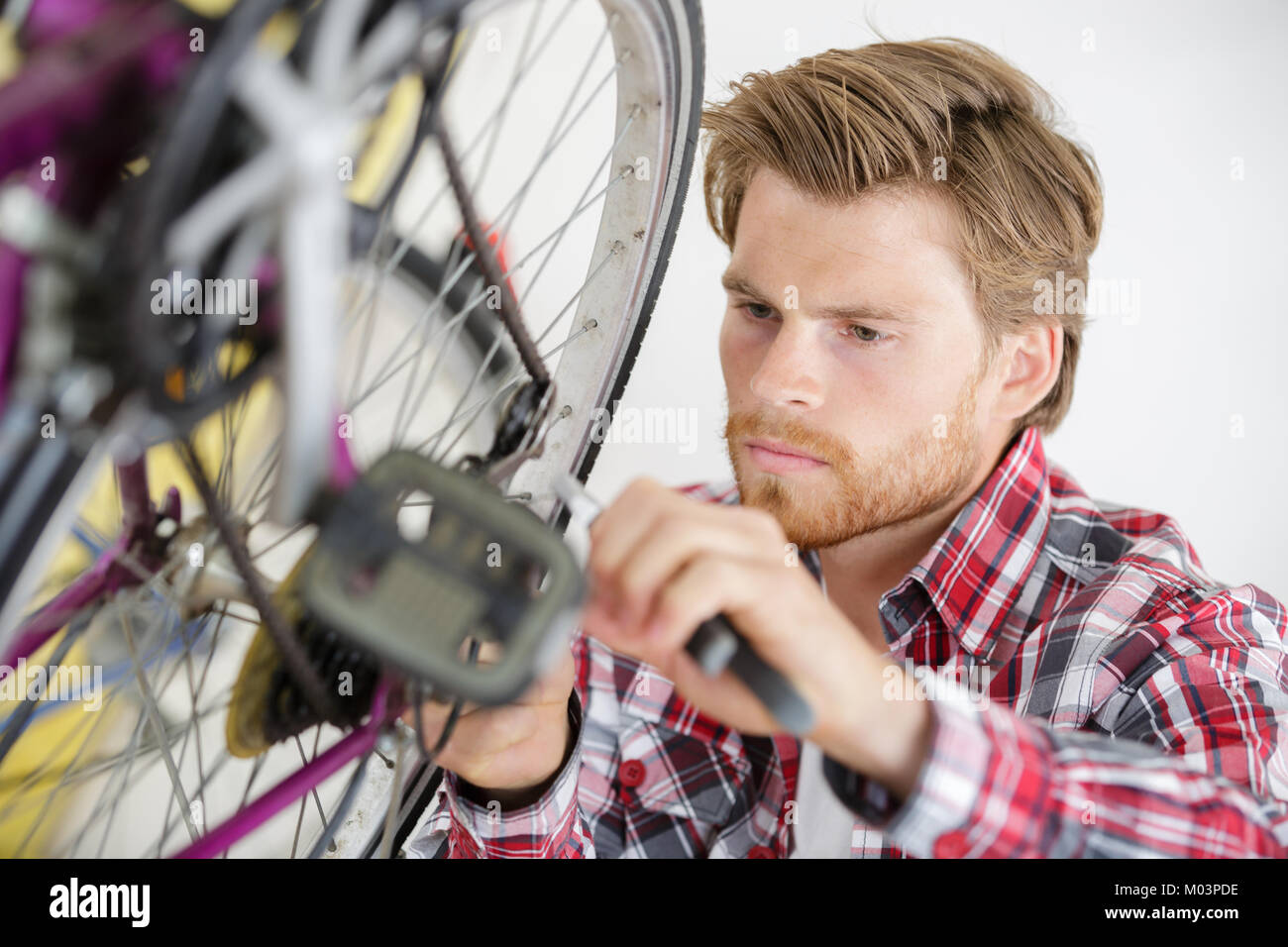 Man fixing bicycle wheel Stock Photo - Alamy