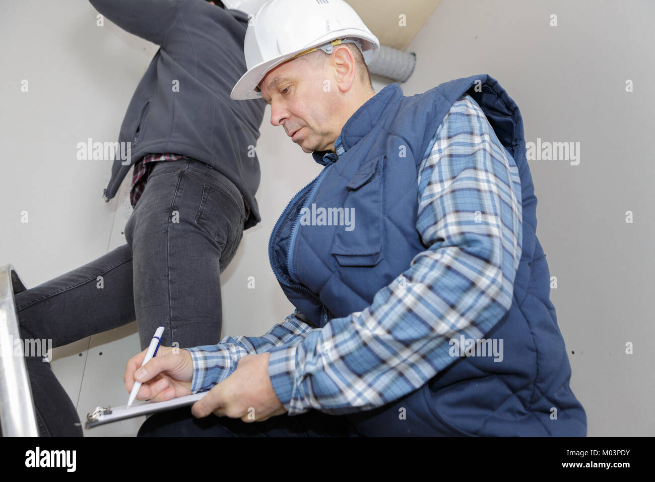 construction manager writing on a clipboard Stock Photo - Alamy
