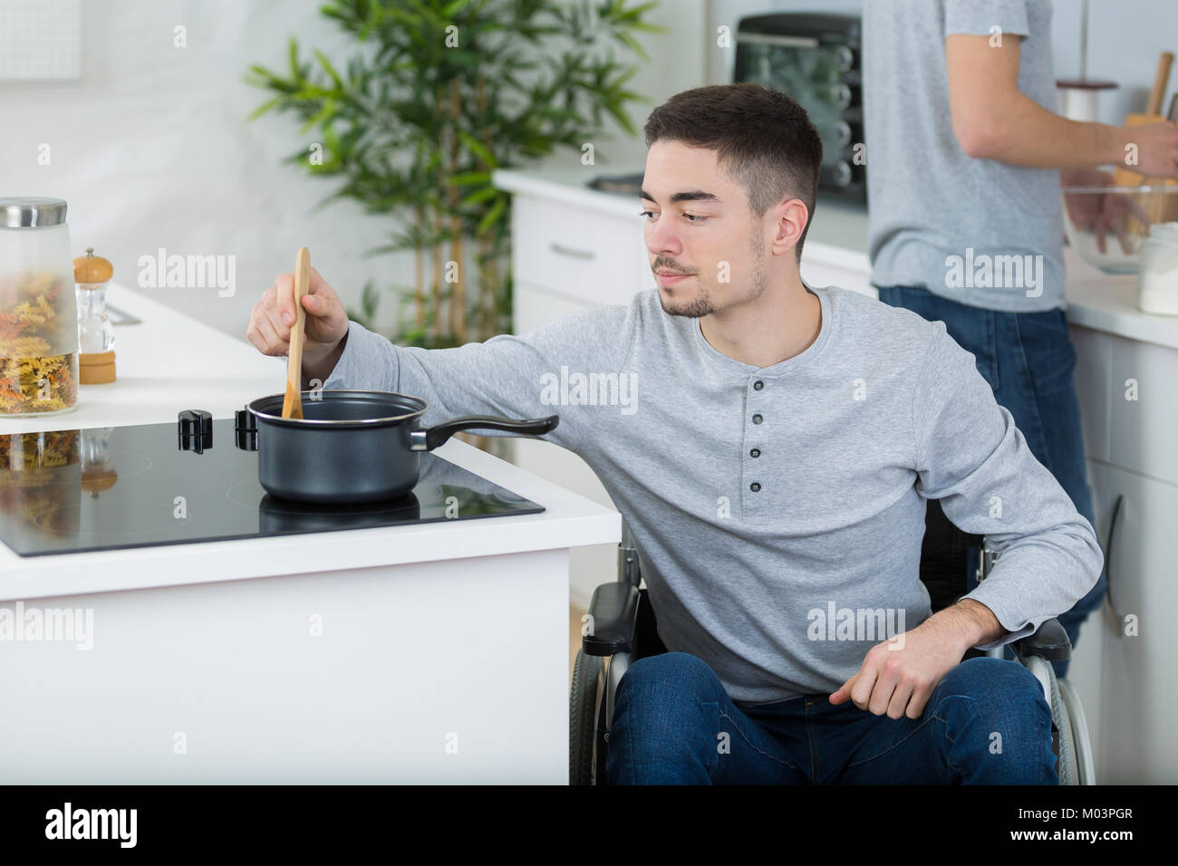 disabled young man is cooking a meal in the kitchen Stock Photo - Alamy