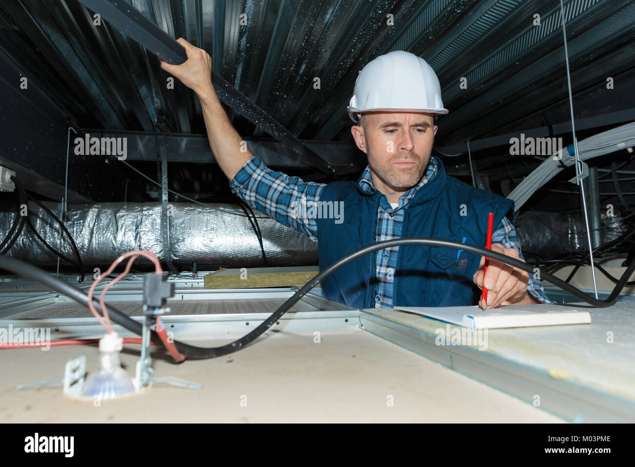 man repairing electrical wiring on the ceiling Stock Photo - Alamy