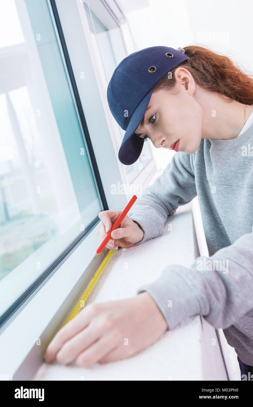 young woman measuring the wall with tape measure Stock Photo - Alamy