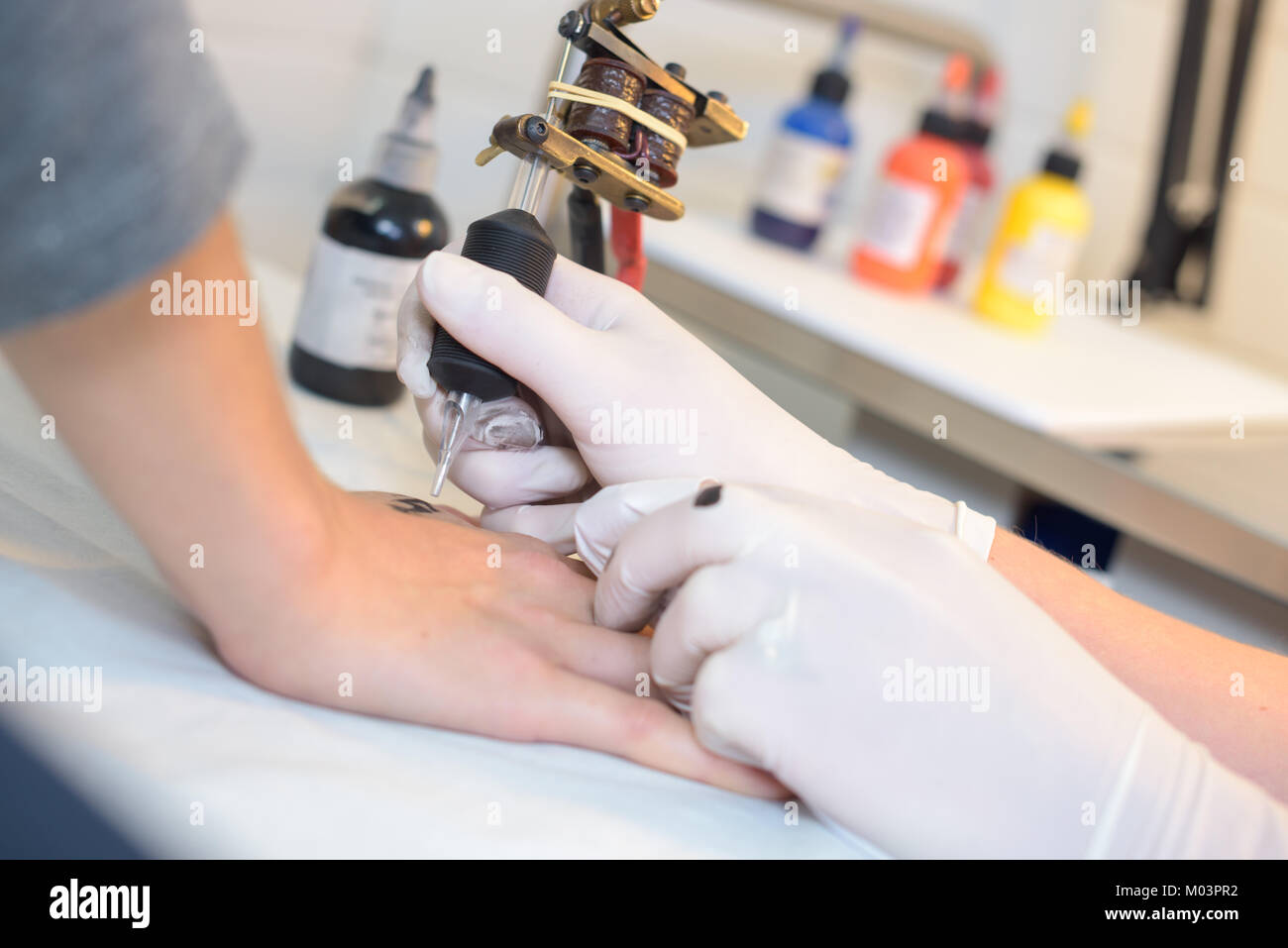 Woman having tattoo on hand Stock Photo - Alamy
