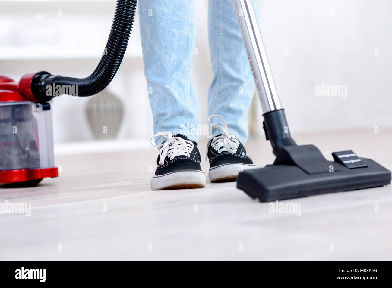 young woman hoovering in living room Stock Photo - Alamy