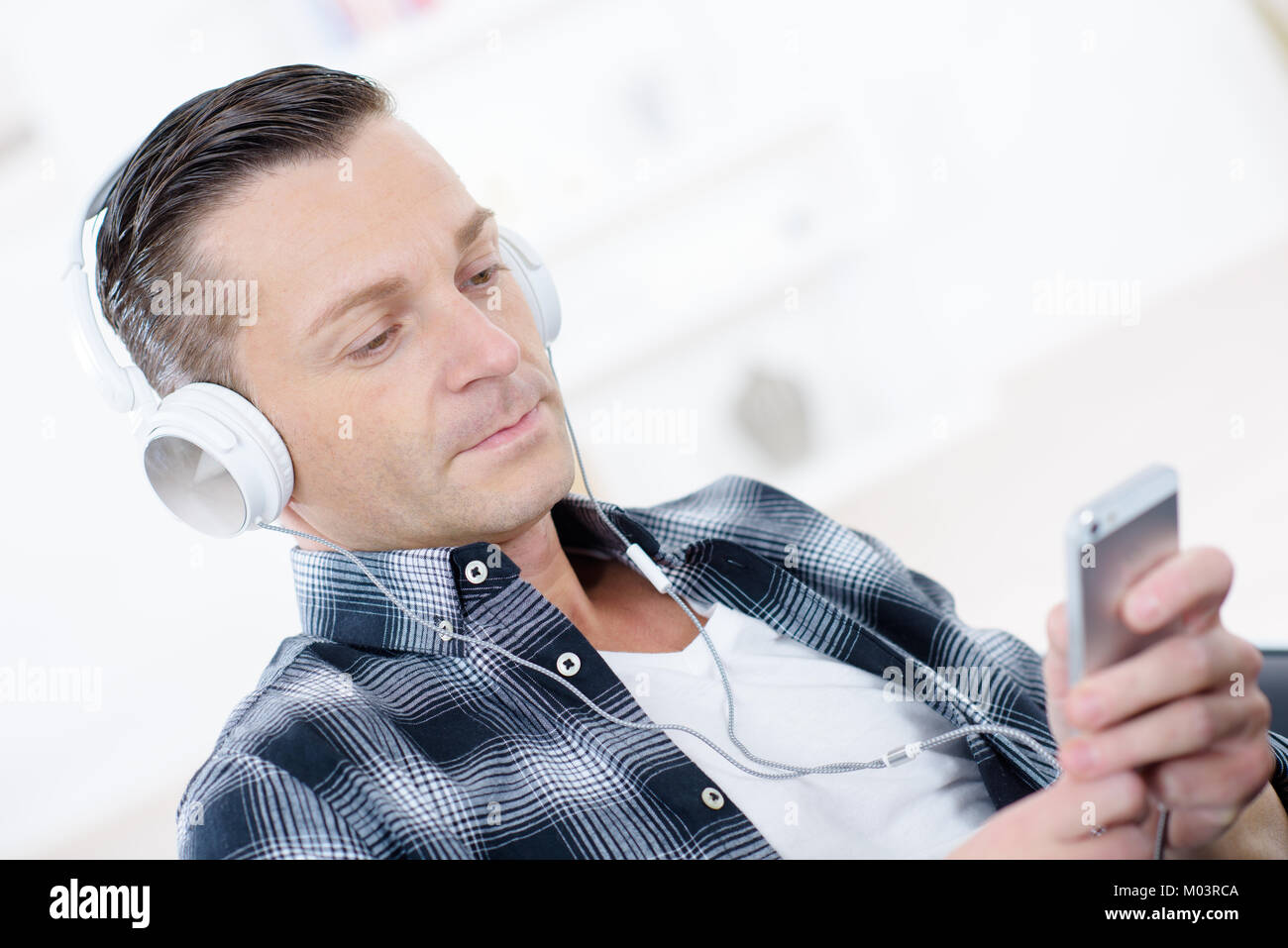 middle aged casual man with headphone relaxing at home Stock Photo - Alamy