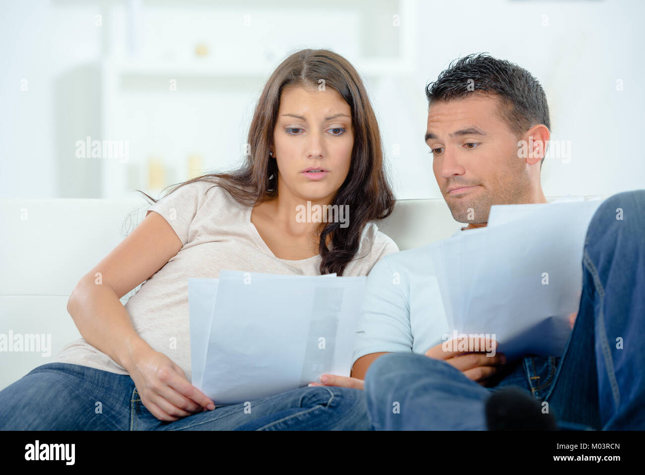 Worried couple looking at paperwork Stock Photo - Alamy