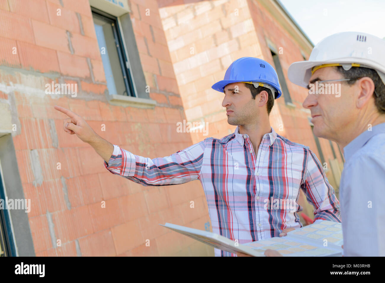 Foreman pointing at unfinished house Stock Photo - Alamy