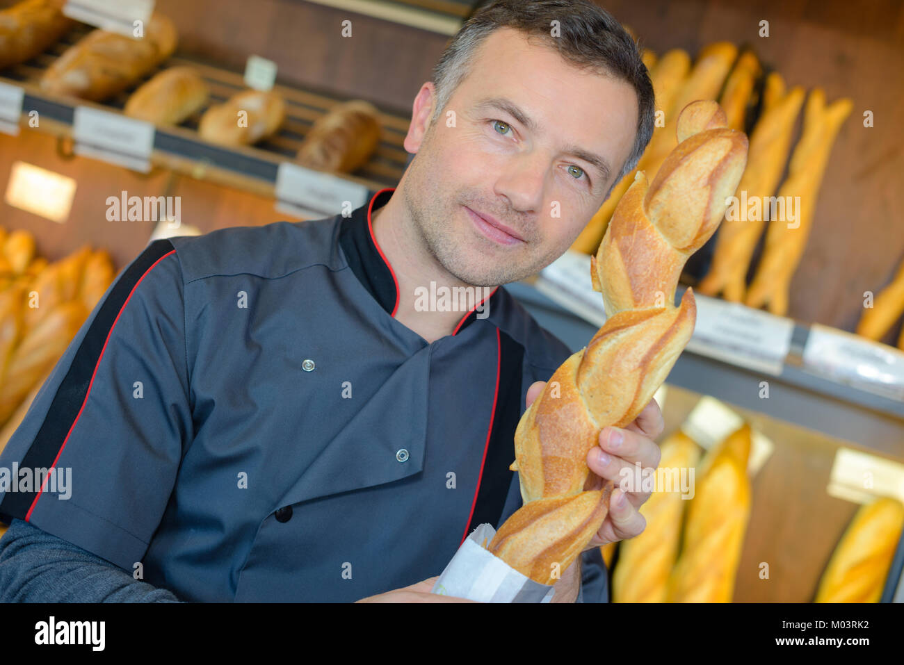 bakery shopkeeper is proud of his bread production Stock Photo - Alamy