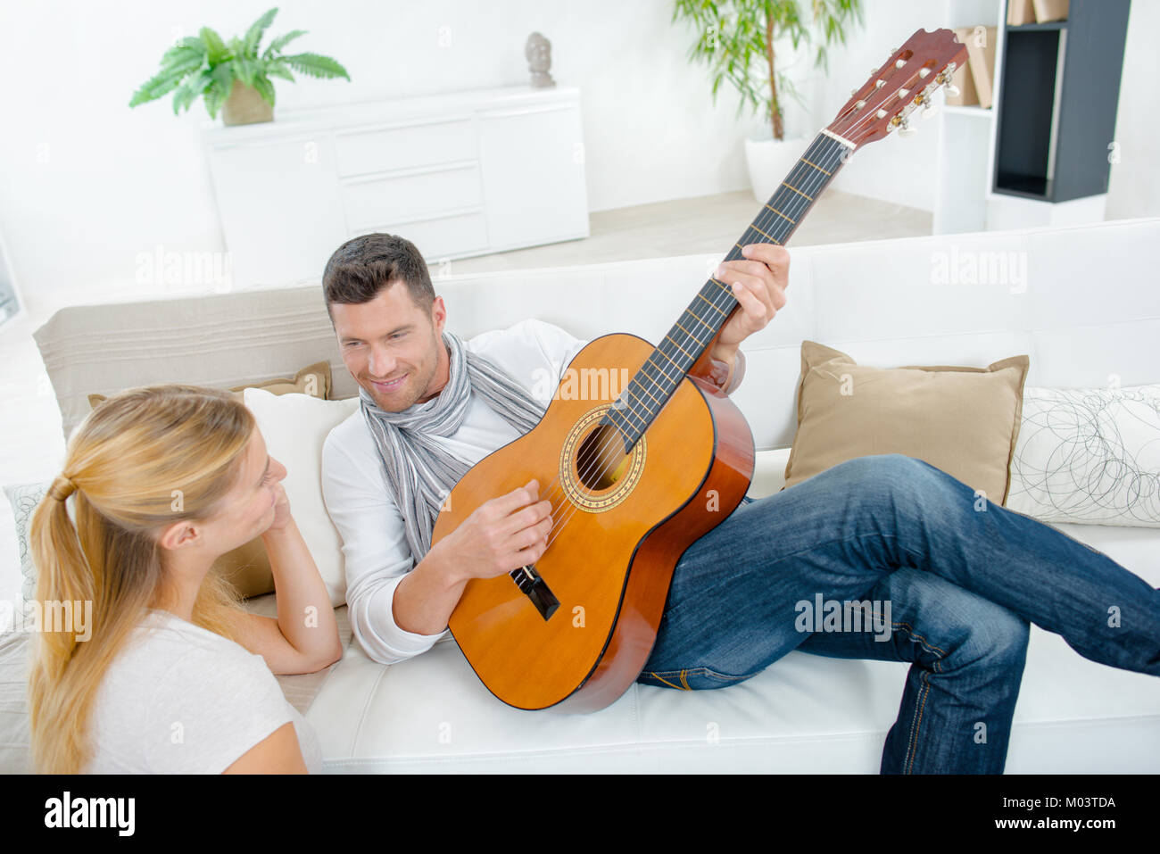 man playing guitar on couch Stock Photo - Alamy