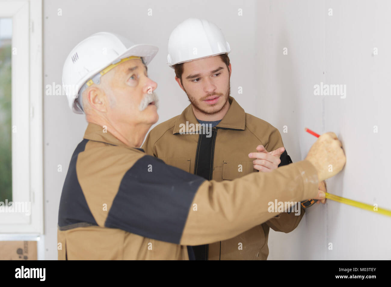 builders drawing line on wall Stock Photo - Alamy