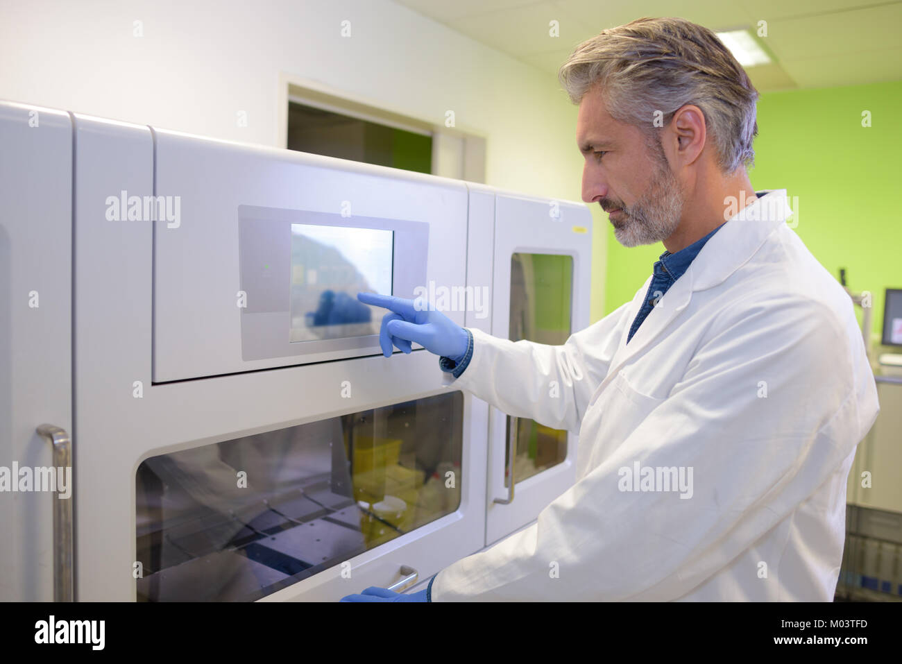 Laboratory worker pointing inside machine Stock Photo - Alamy