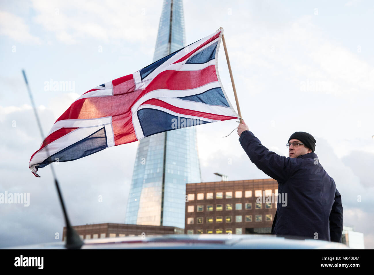 London, UK. 18th January, 2018. A black cab driver waves a Union Jack ...