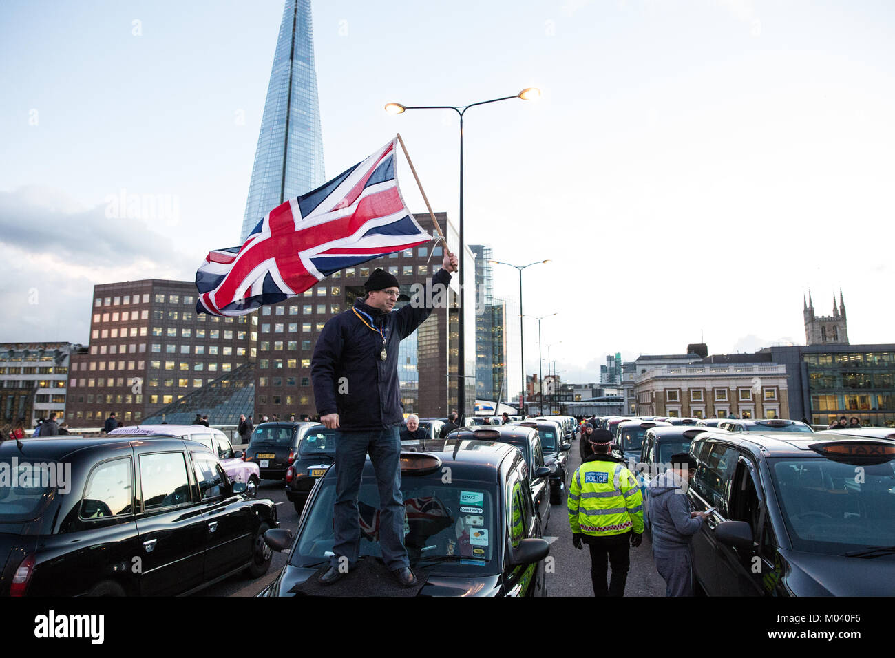 London, UK. 18th January, 2018. A black cab driver waves a Union Jack ...