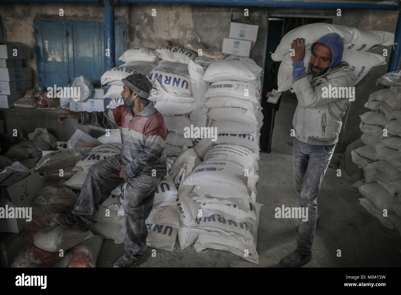 Gaza City, Gaza. 18th Jan, 2018. A Palestinian man carries sacks of ...
