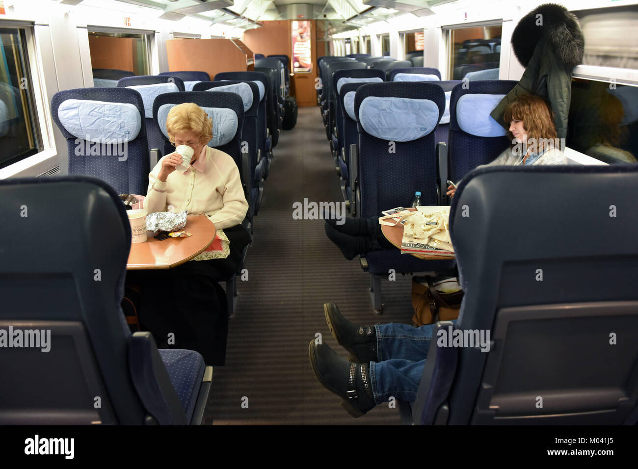 Stranded passengers sit in a stationary train at the train station ...
