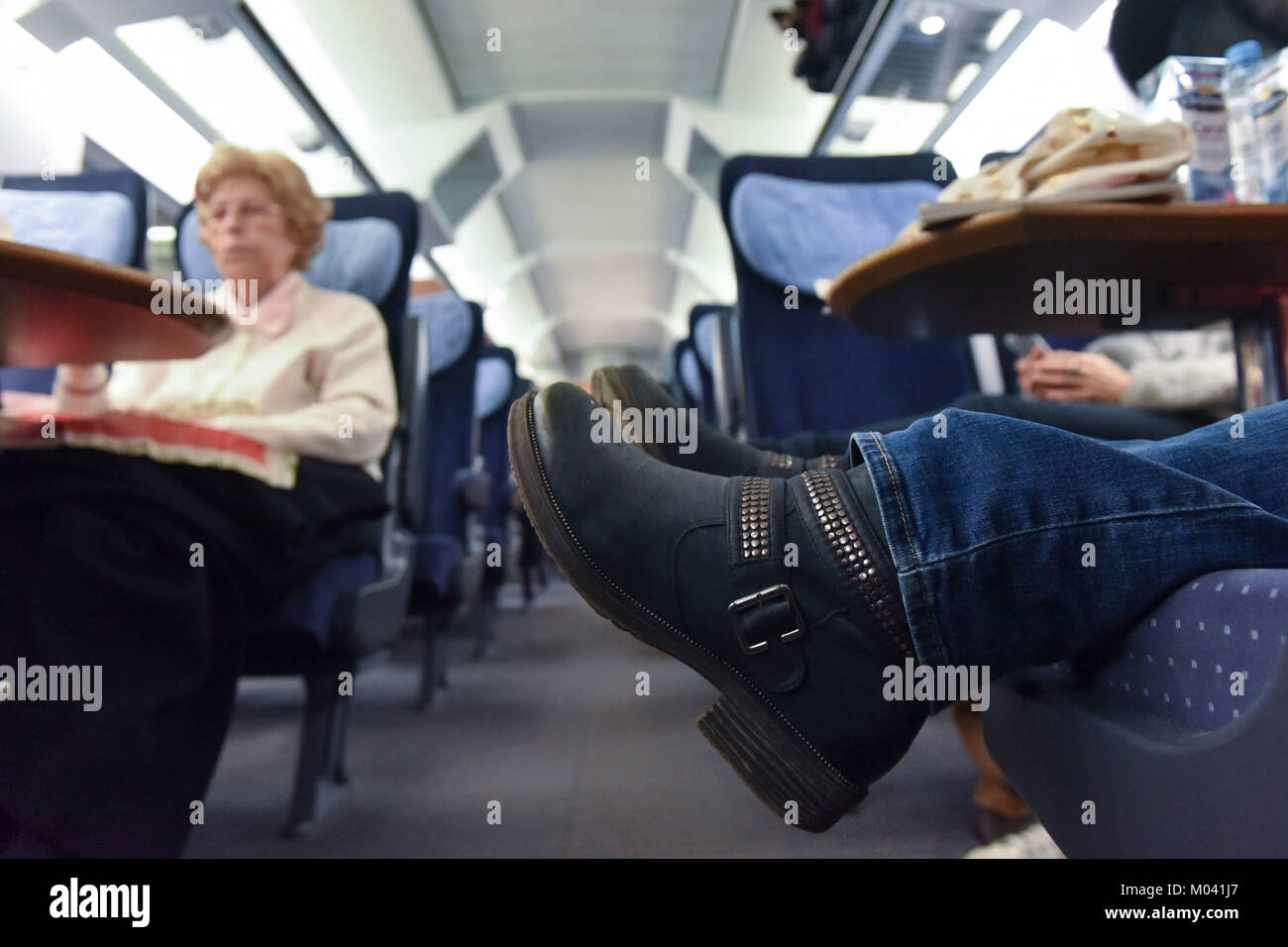 Stranded passengers sit in a stationary train at the train station ...