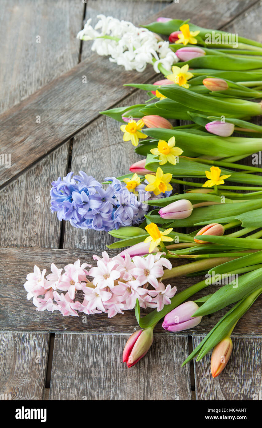 Colorful spring flowers on a rustic wooden background Stock Photo - Alamy