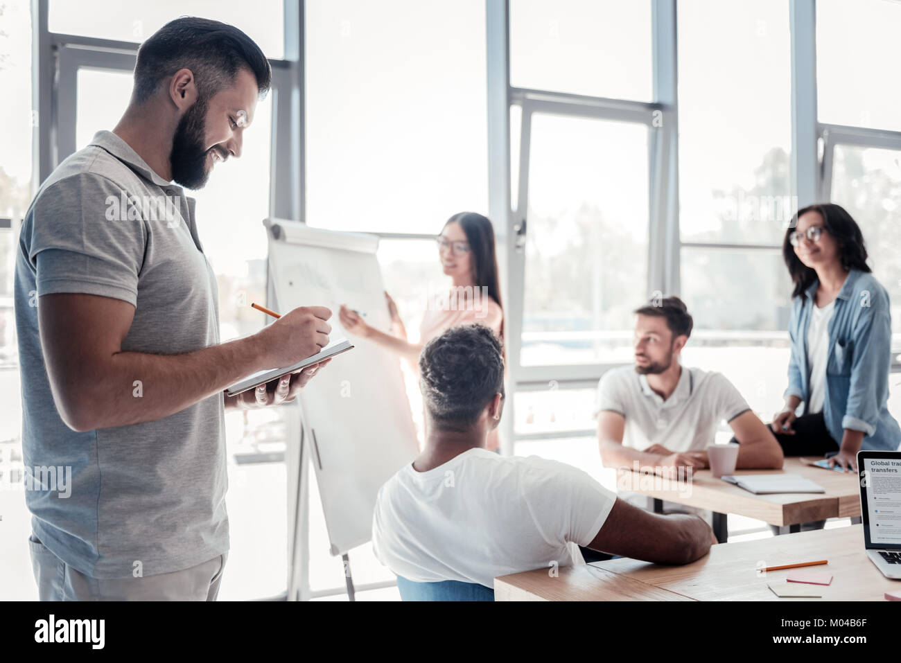 Young man taking notes during office meeting Stock Photo - Alamy
