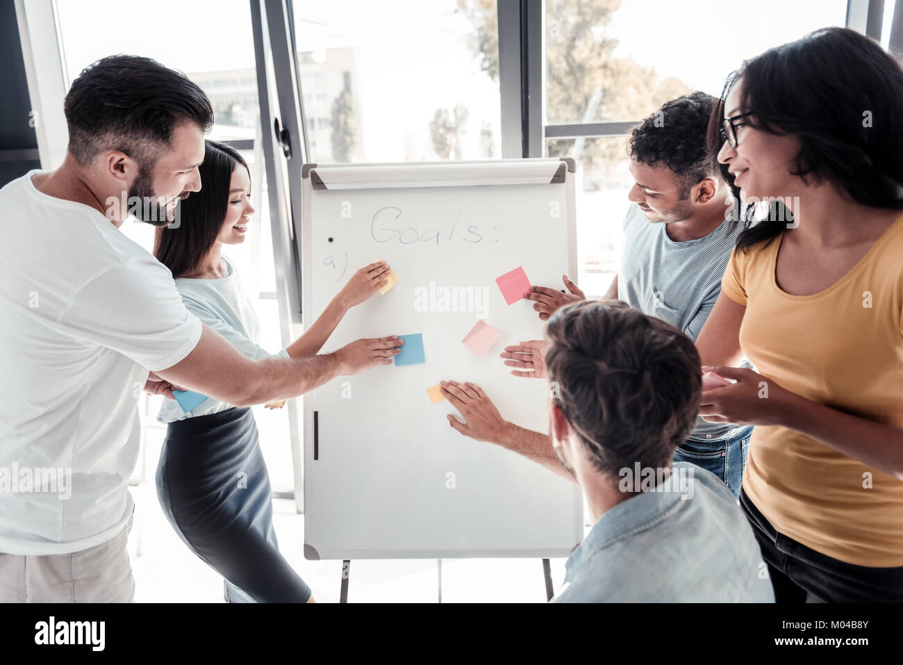 Cheerful colleagues setting business goals in office Stock Photo - Alamy
