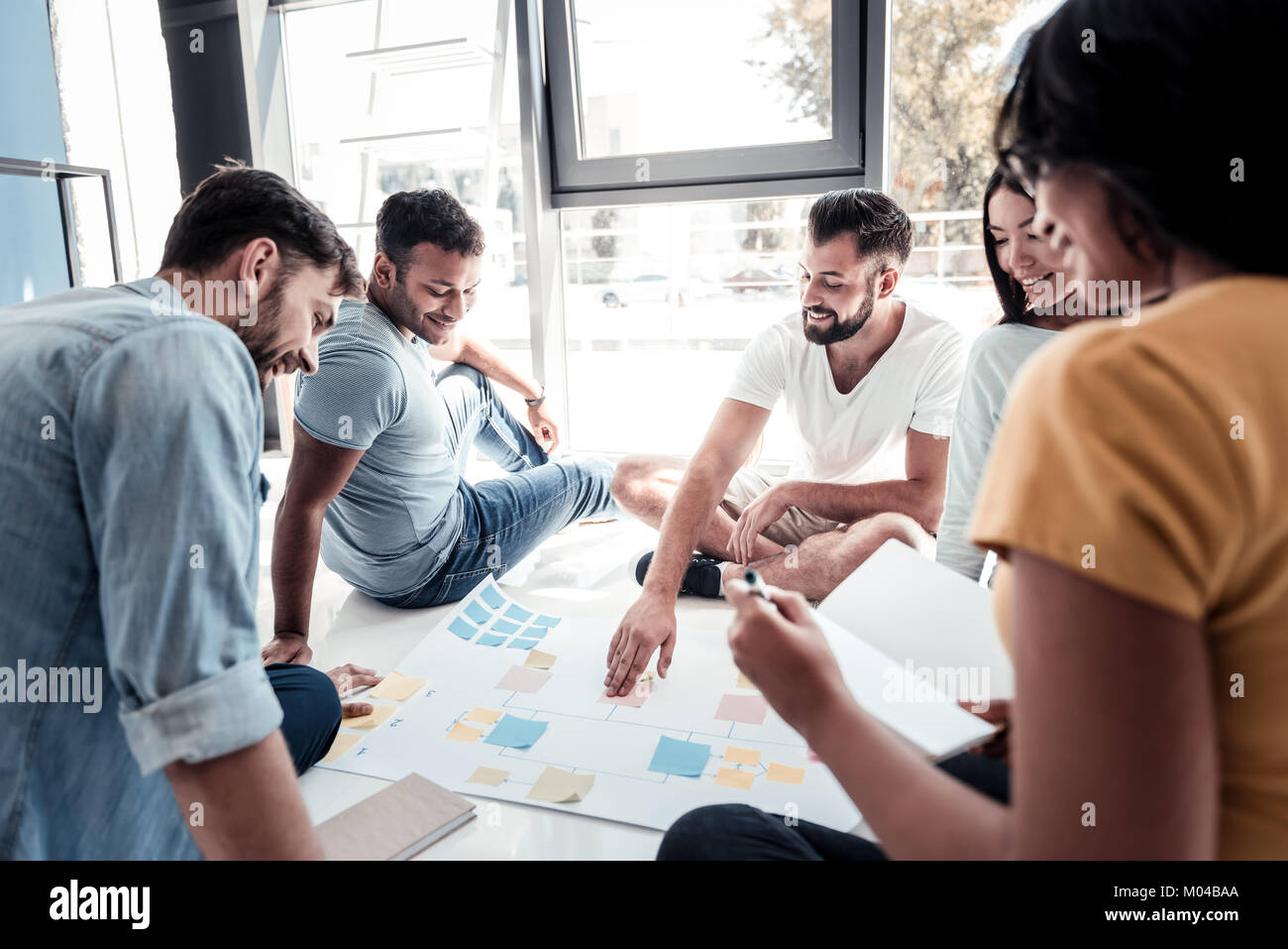 Cheerful students discussing home assignment together Stock Photo - Alamy