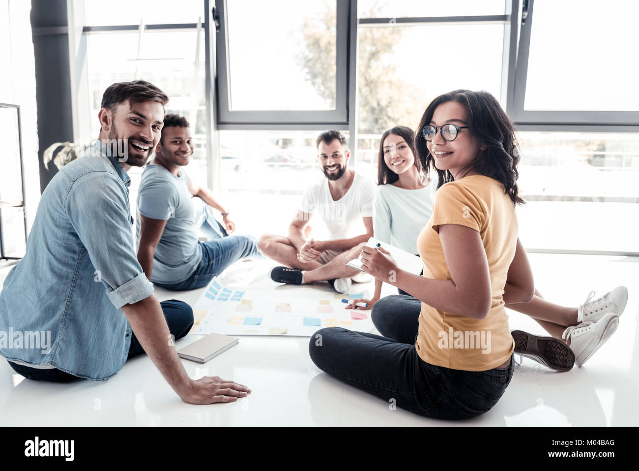 Young people in casual smiling while working on project Stock Photo - Alamy