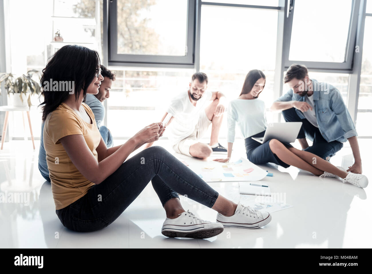 Relaxed students sitting on floor and studying Stock Photo - Alamy