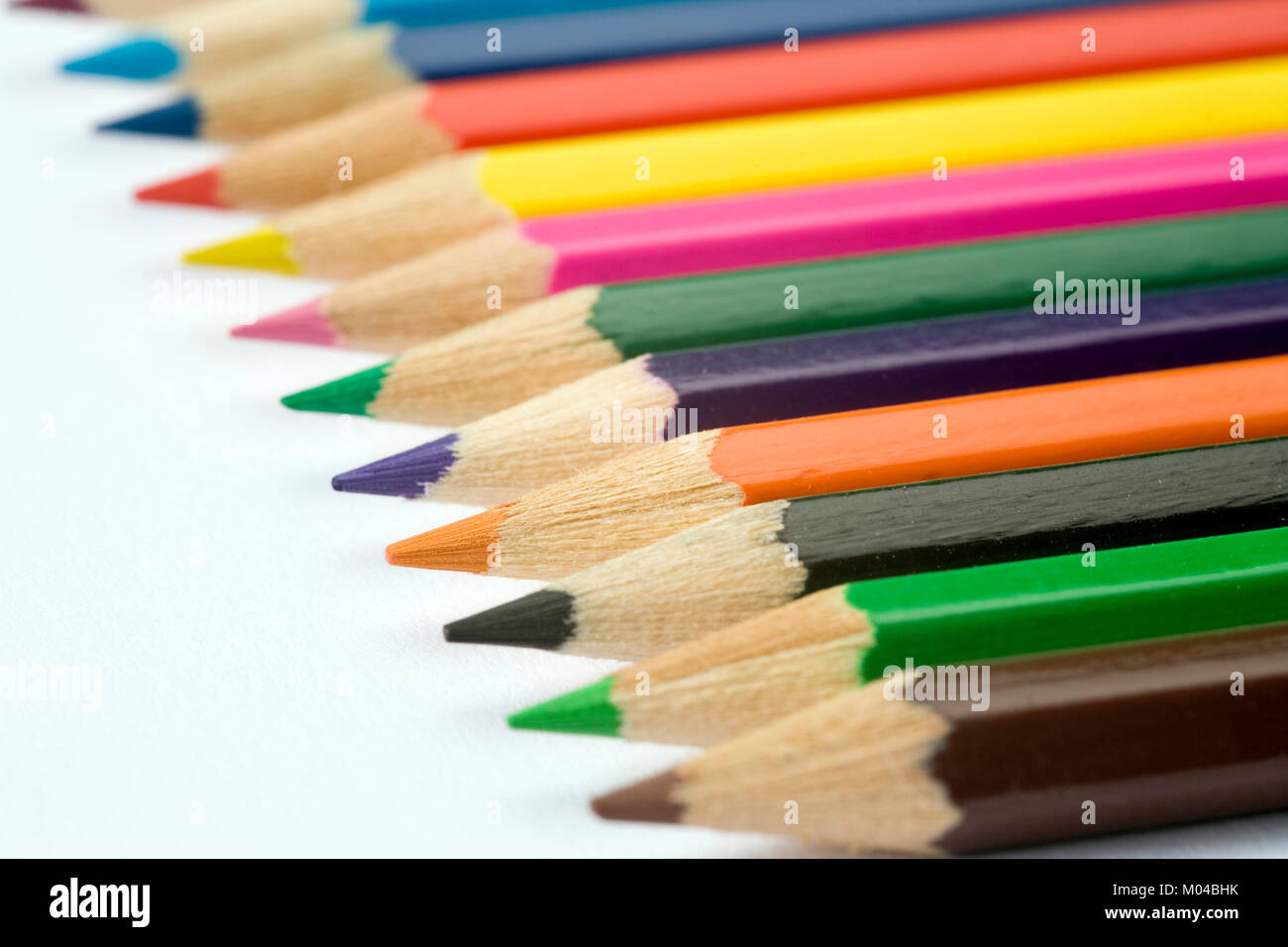 Childrens colouring pencils on a plain white textured paper background ...