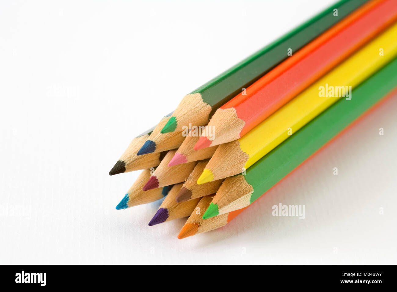 Childs colouring pencils on a plain white textured paper background ...