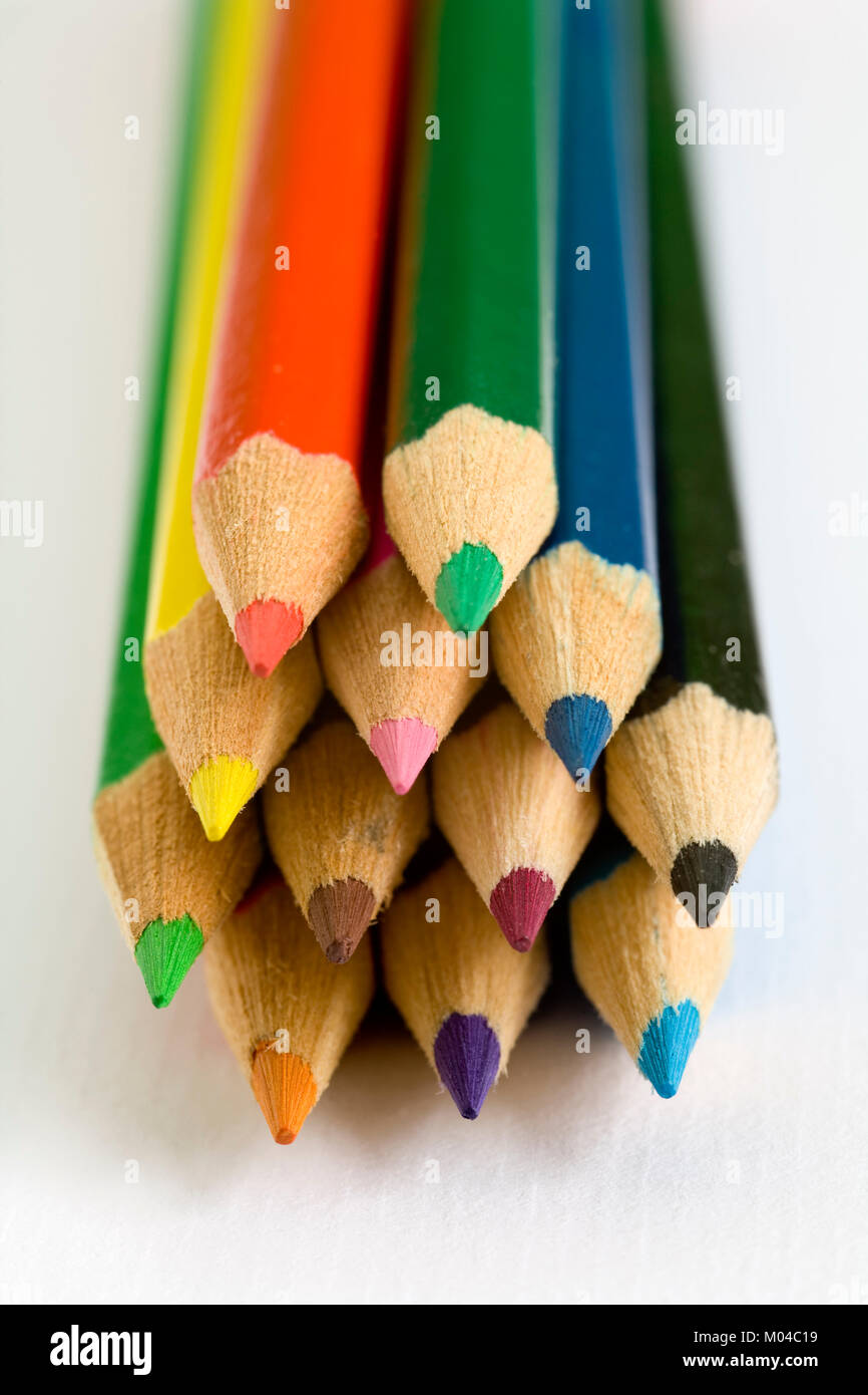 Childs colouring pencils on a plain white textured paper background ...