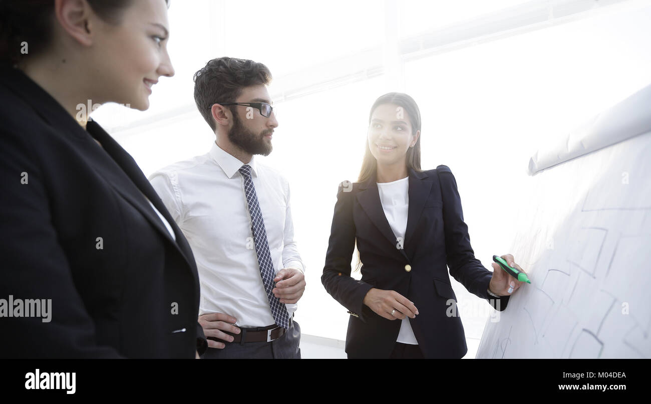 businesswoman pointing marker to flipboard on presentation in office ...