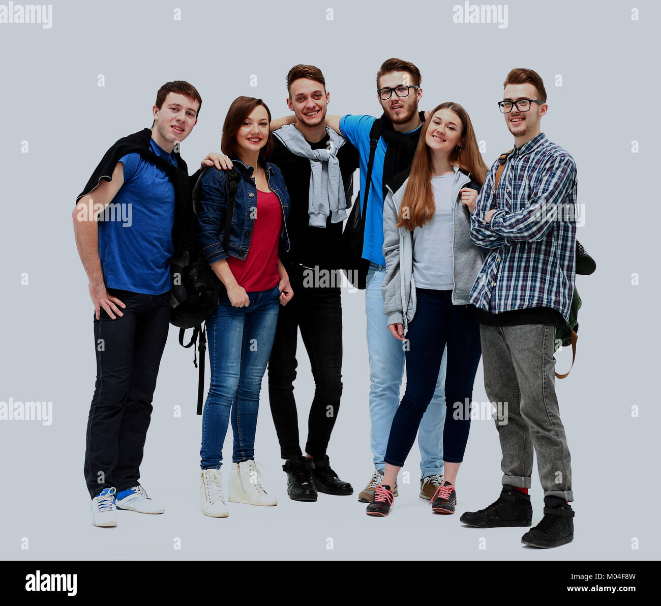 group of smiling friends staying together and looking at camera ...