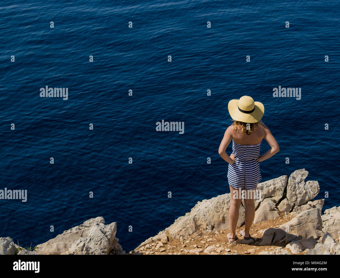 Girl on a cliff next to the sea Stock Photo - Alamy