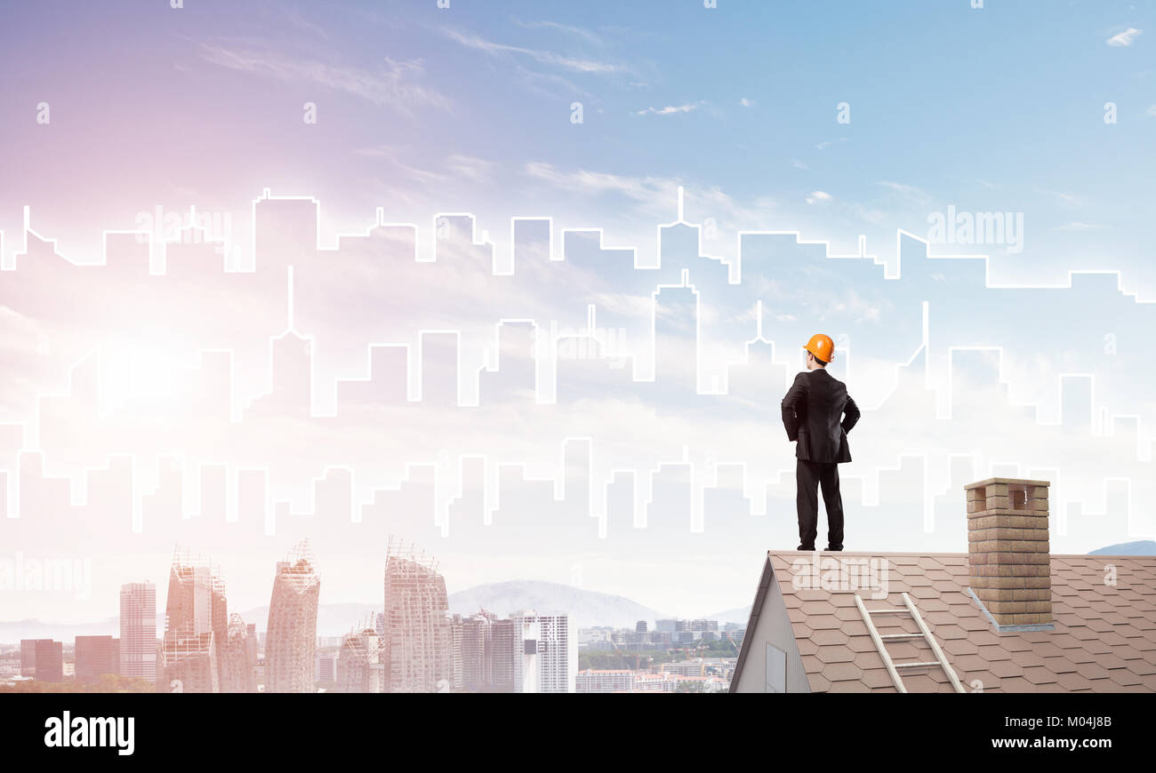 Engineer man standing on roof and looking away. Mixed media Stock Photo ...
