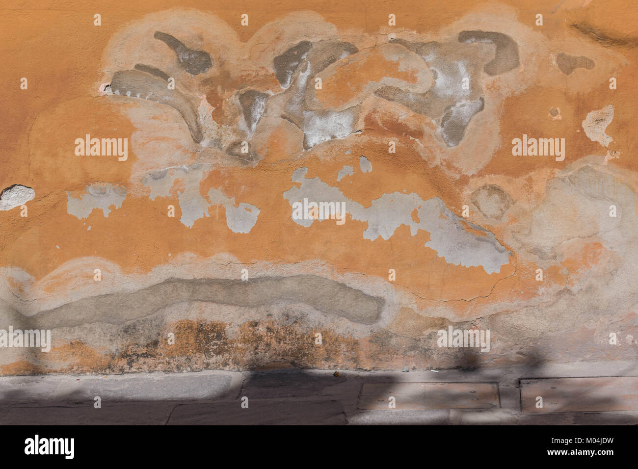 An old yellow stucco wall with chipping paint, creating interesting ...