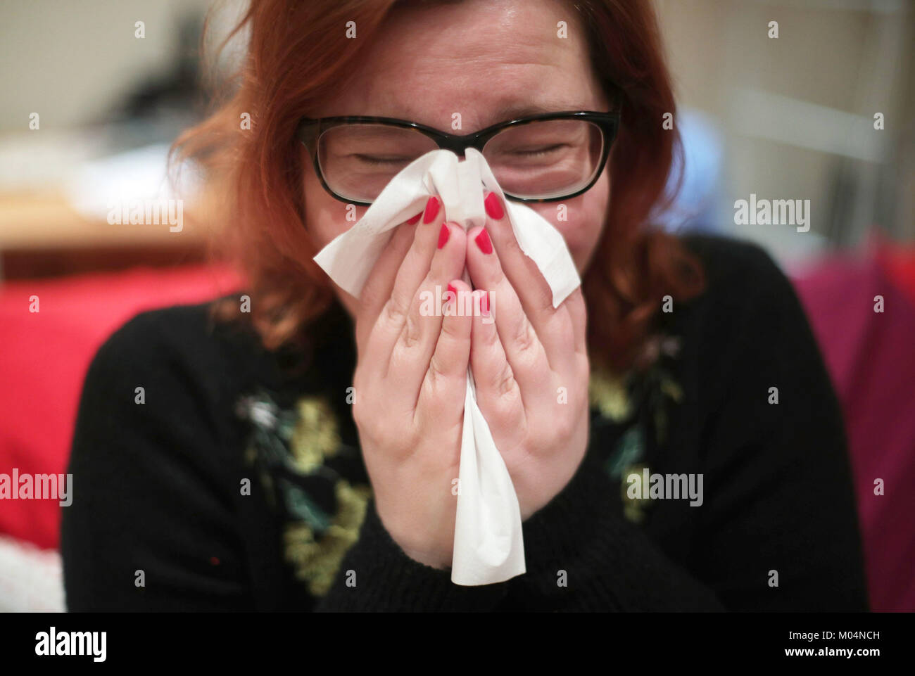 A woman with a cold blowing her nose with a tissue, in London Stock ...