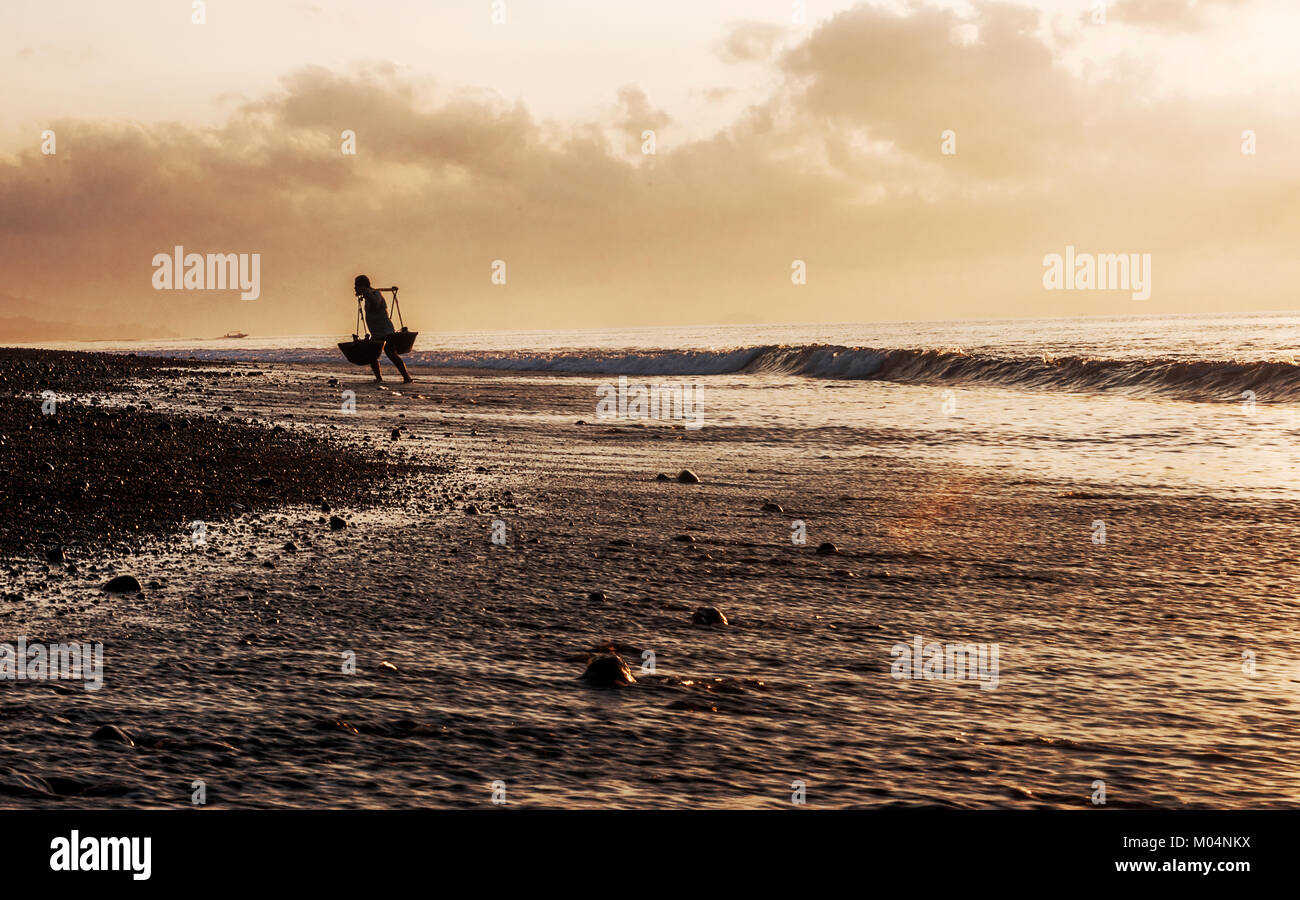 Indonesian salt farmer of Kusamba salt mining village in Bali ...