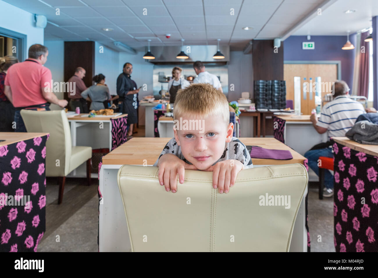 Child peering over back of chair hi-res stock photography and images ...