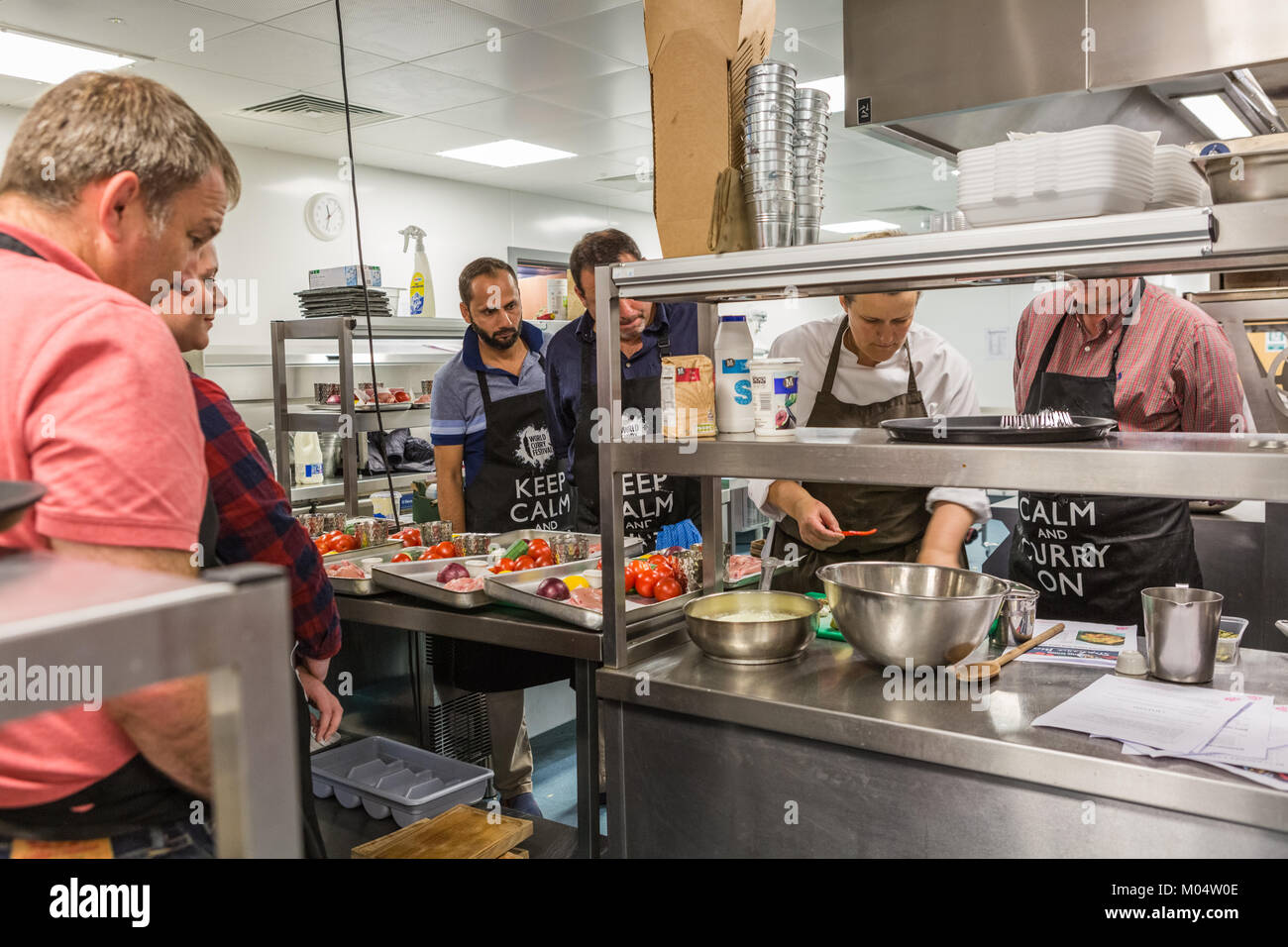 Students watching and learning from chef during a cooking demonstration ...