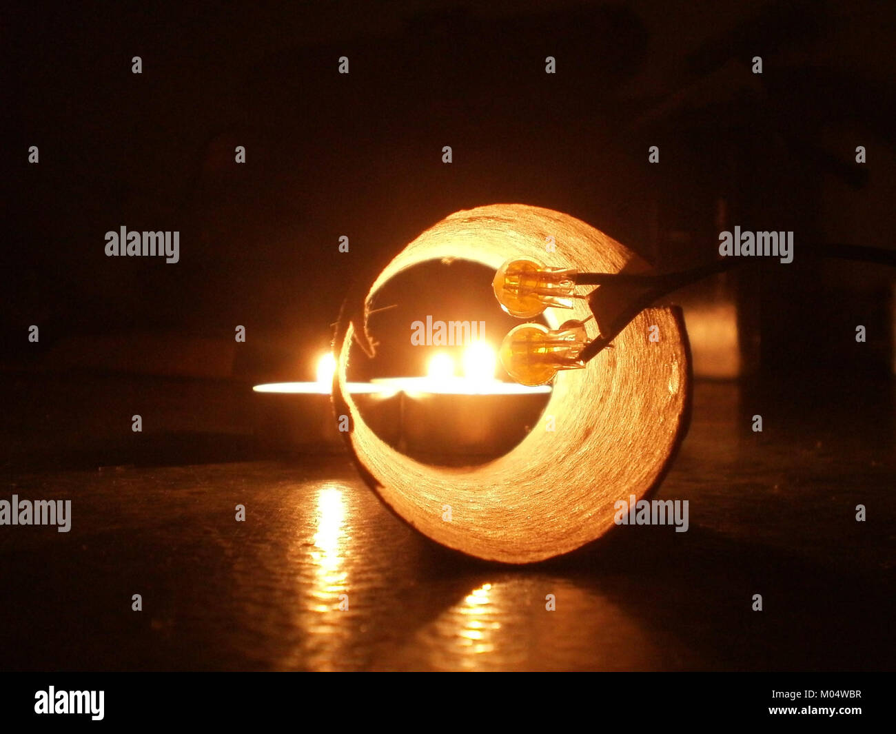 A photograph of candles and a photocell, depicting the contrast between ...
