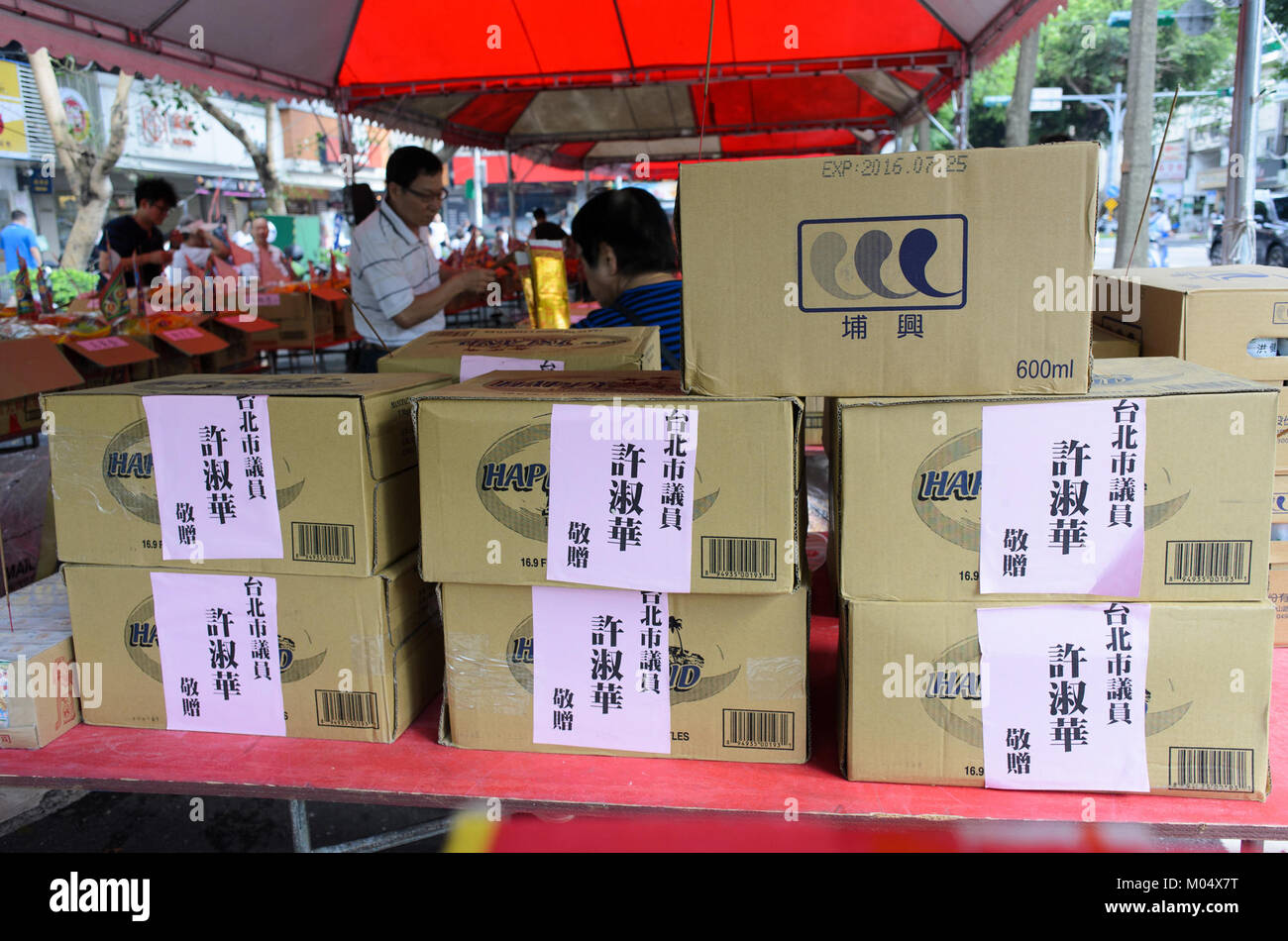 This photograph depicts bottled water boxes arranged on a table ...