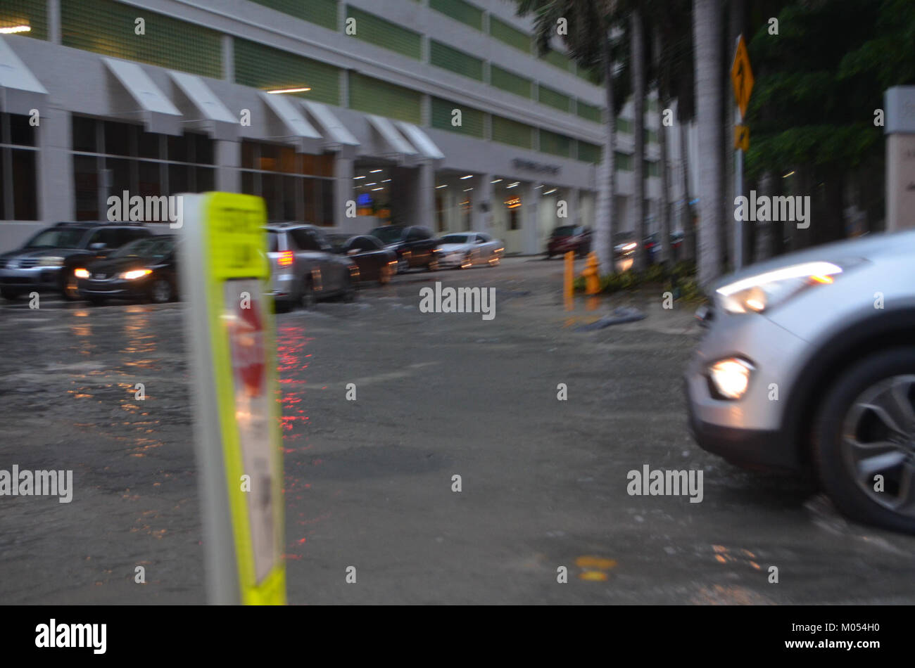 The image depicts water from high tide flooding the streets of Brickell ...