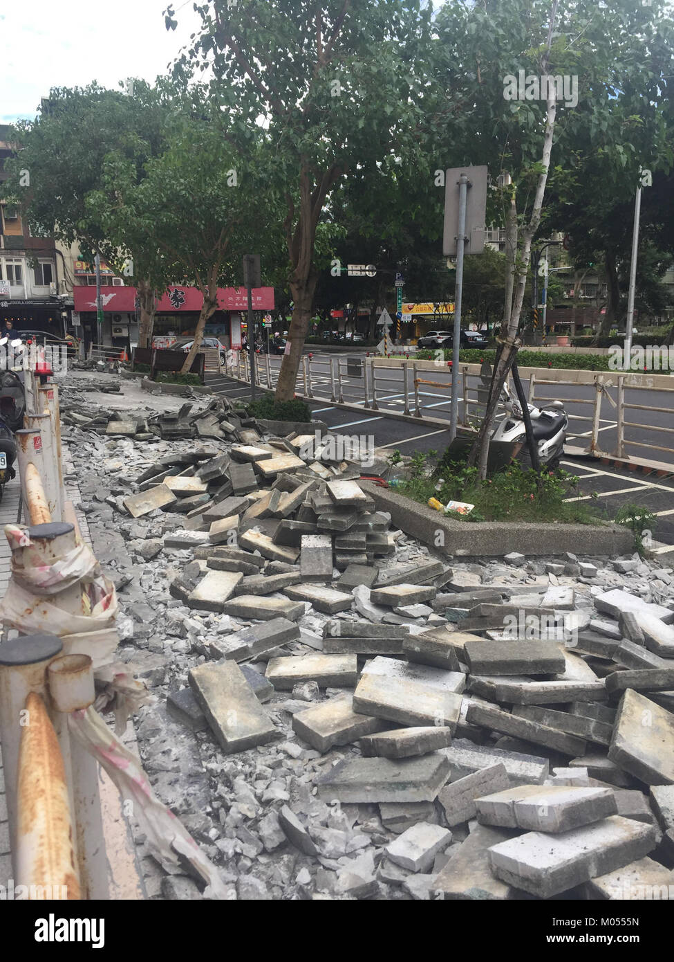 The image depicts broken bricks on the sidewalk of Sanmin Road in ...