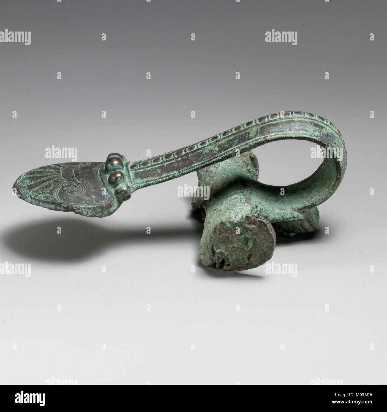 This bronze handle belongs to an oinochoe, an ancient Greek jug used ...