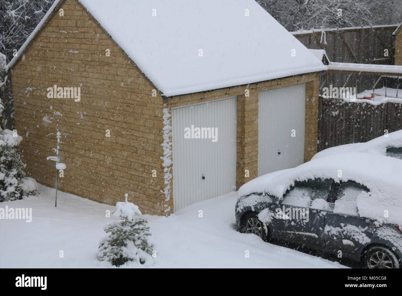 Garages with build up of snow and car parked Stock Photo - Alamy