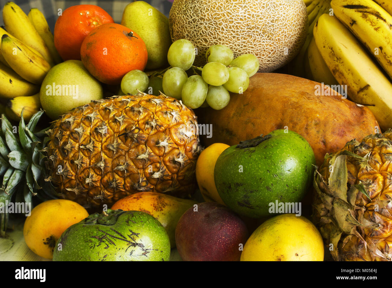 stack of different fruits, banana, cavendish, pineapple, grape, mango ...